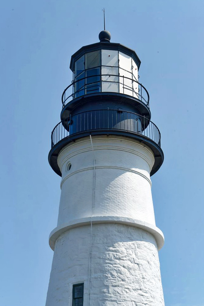 The distinctive black lantern room crowns this historic structure, housing the powerful light that continues its centuries-old mission.