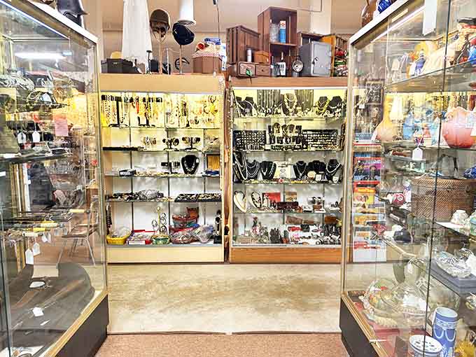 Display cases glitter with vintage jewelry and collectibles, each tiny treasure representing someone's special occasion or everyday adornment from decades past.