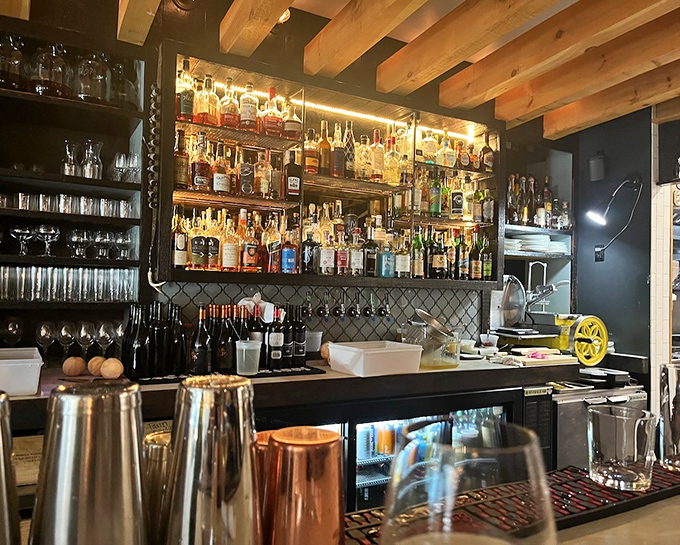 Behind the bar, bottles gleam like jewels against tiled backsplash, each one holding potential for the perfect pairing with your meal.