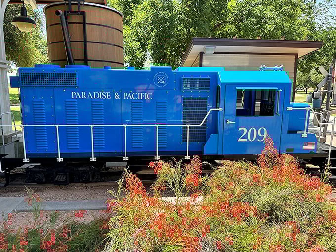 The Paradise & Pacific's blue diesel locomotive #209 stands ready for duty, surrounded by desert blooms that add splashes of color.