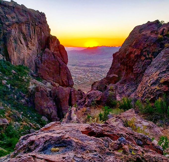 The sun bids farewell through a natural frame of ancient rock, painting the valley in liquid gold.