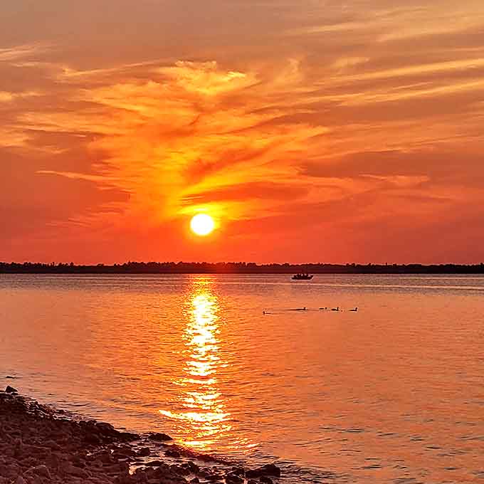 Nature's farewell performance: The sun dips below Lake Huron's horizon, painting the sky in impossible colors while ducks applaud the show.