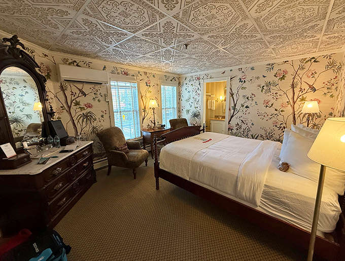 Wallpapered elegance creates a bedroom sanctuary where counting sheep is replaced by counting reasons to extend your stay.