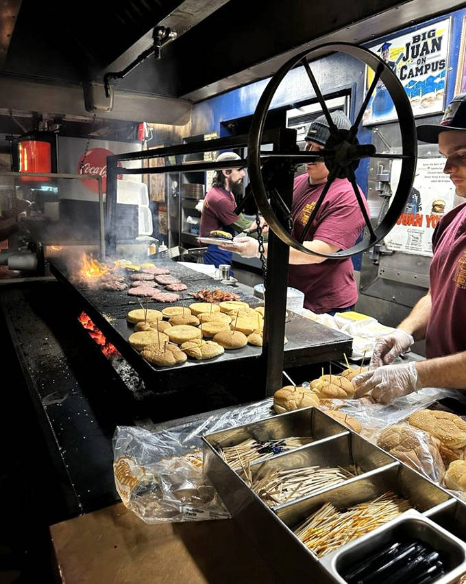 Grill masters at work, wielding spatulas like artists with brushes. That massive wheel isn't for show &ndash; it's burger engineering at its finest.