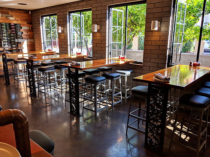High-top tables near expansive windows create a bright, airy dining experience where the Arizona sunshine becomes part of the restaurant's warm ambiance.