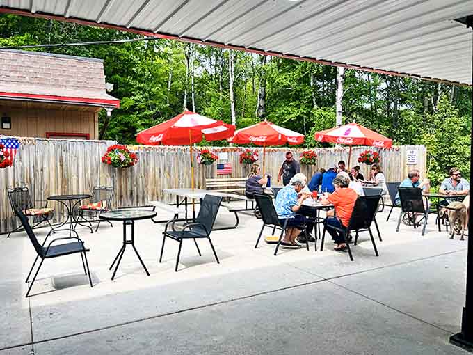 Red umbrellas dot the patio like cherry tops on sundaes, providing shade for patrons enjoying their drive-in treasures.