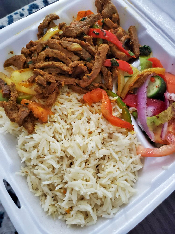 Beef shawarma plate with perfectly cooked rice and fresh salad. A complete meal that balances protein, carbs, and vegetables in harmonious proportion.
