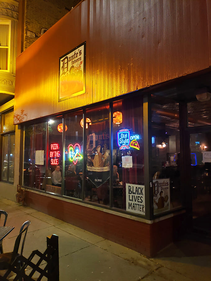 As night falls, Dante's neon signs cast a welcoming glow onto the sidewalk, beckoning pizza lovers inside.