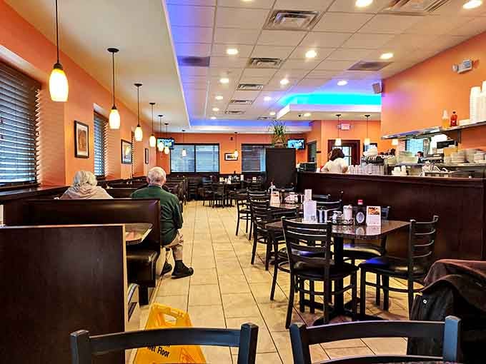 The dining area balances coziness with spaciousness &ndash; orange walls and pendant lighting create an atmosphere that welcomes lingering conversations.