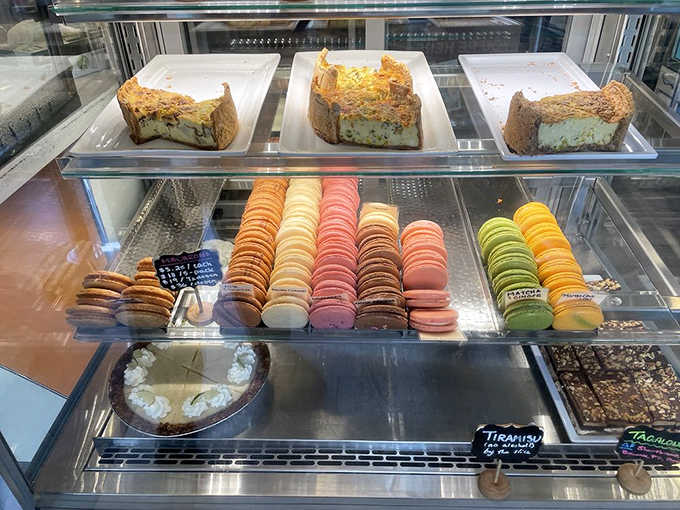 A rainbow of macarons stands at attention below quiche sentinels &ndash; this display case isn't just refrigerated, it's curated.