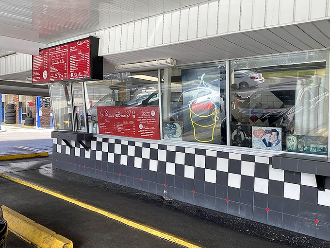 The drive-in window keeps the car-hop tradition alive, where modern vehicles line up for an experience their grandparents would recognize.