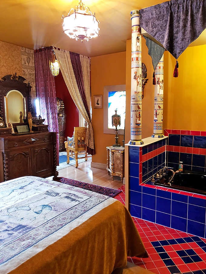 Gold and blue tones dominate this Egyptian-themed bedroom, where ancient history meets comfortable modern accommodations.