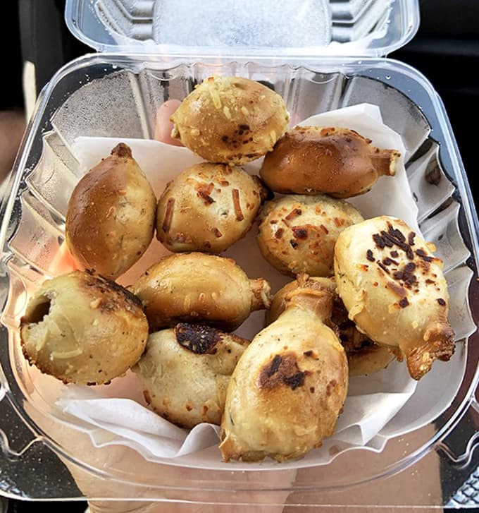 Garlic knots that glisten with buttery goodness &ndash; little bundles of joy that are impossible to eat just one of.