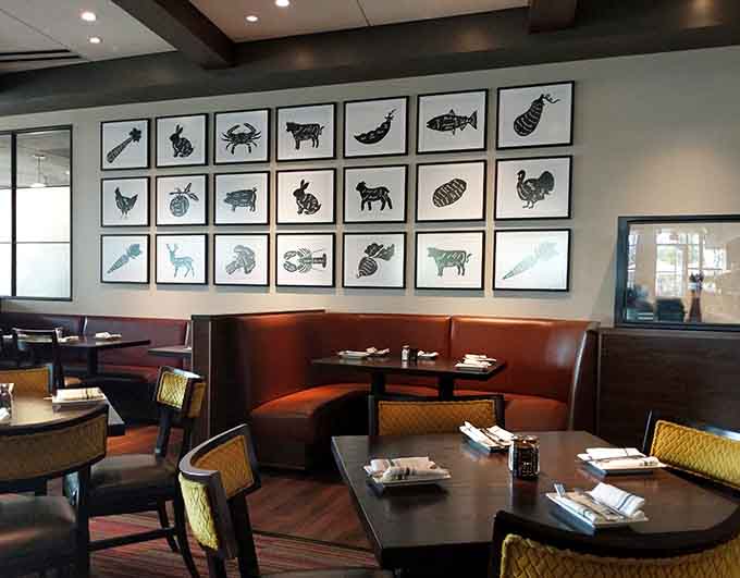 Curved booth seating and playful food-themed artwork create intimate dining nooks perfect for date nights or family gatherings.