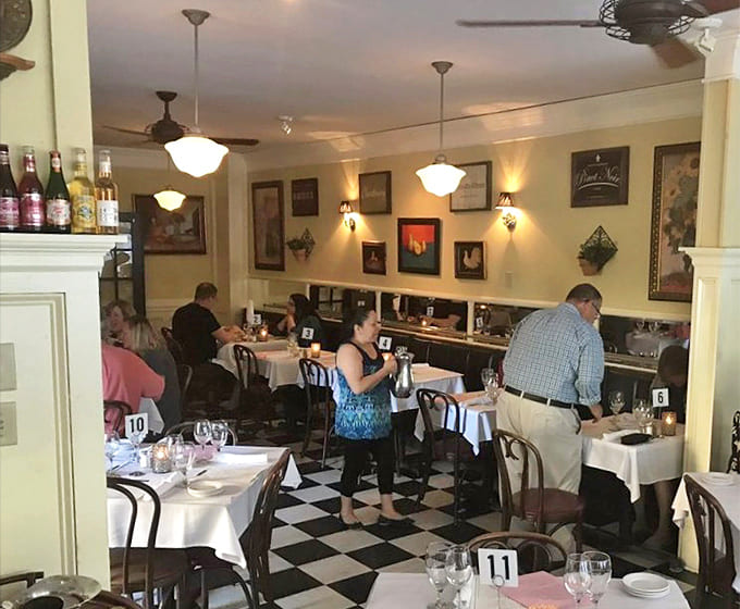 Diners enjoy the warm ambiance surrounded by vintage d&eacute;cor and wine displays that enhance the European bistro experience.