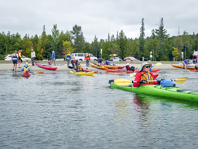A rainbow of kayaks prepares to explore Willoughby's shores, each paddler about to discover their own perfect cove or hidden beach.