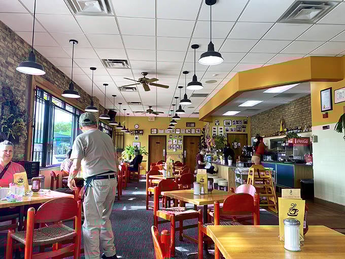 The café's interior strikes that perfect balance between spacious and intimate, with exposed brick walls adding warmth to the cheerful yellow paint.