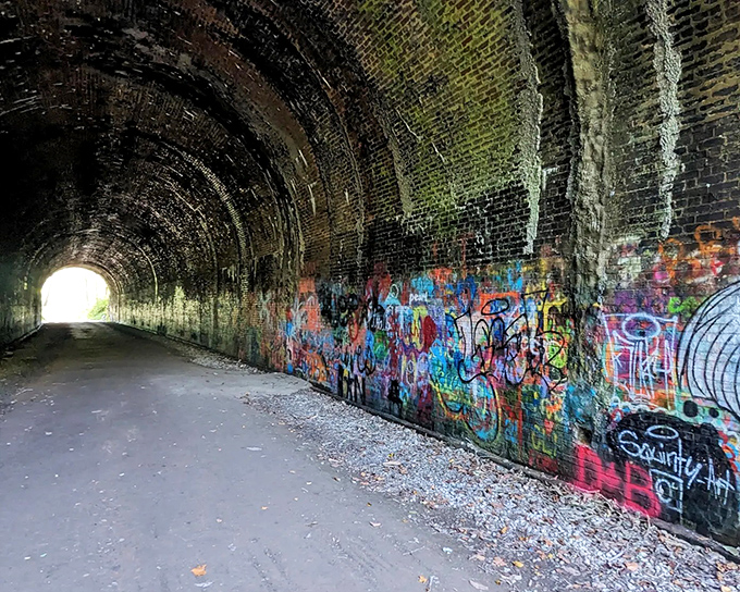 Inside the tunnel, colorful street art creates a striking contrast against the century-old brickwork and industrial architecture.