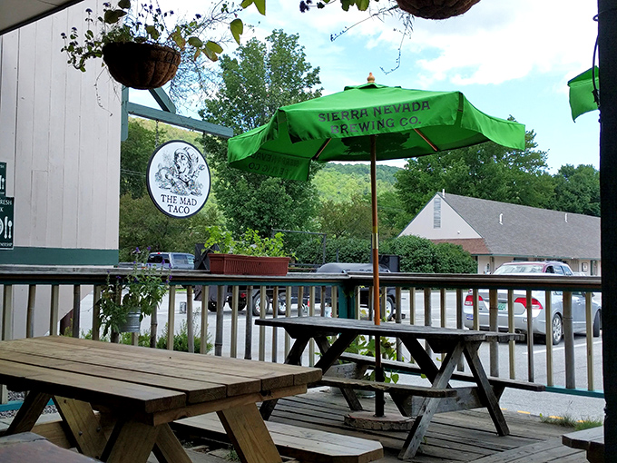 Picnic tables under green umbrellas offer the perfect perch for people-watching while savoring your Mad Taco treasures.