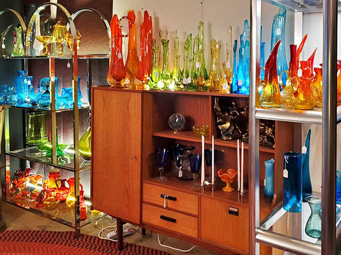 Colored glass catches light like liquid jewels &ndash; a rainbow of vintage vessels from emerald green to cobalt blue, each piece more vibrant than the last.