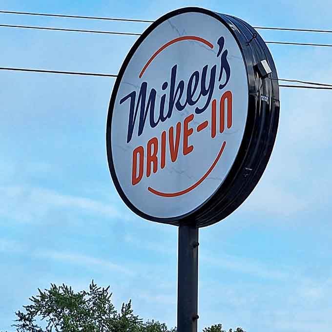 The circular Mikey's sign stands as a beacon of hope for hungry travelers, promising honest food and a brief escape from modern complications.