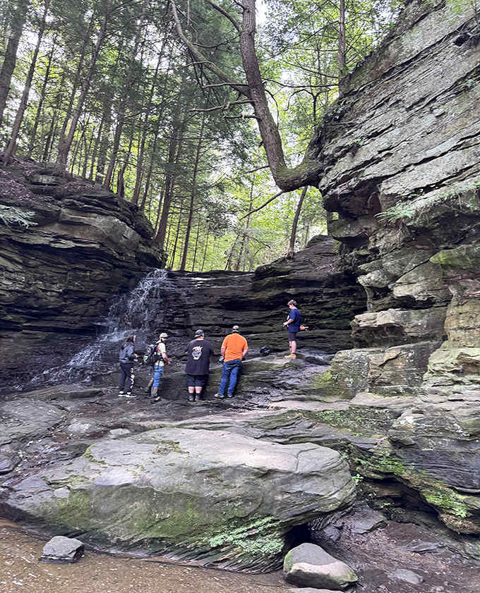 The waterfall's rock formations create a natural gathering space where visitors can experience the soothing soundtrack of falling water.