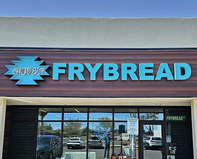 The distinctive turquoise logo pops against warm wood tones, creating a sign that's become a beacon for frybread enthusiasts throughout Phoenix.
