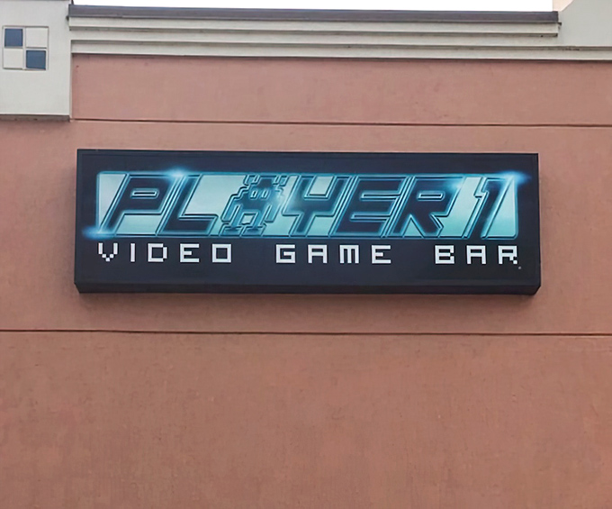 Player 1's exterior signage glows with electric blue promise against the night sky, a modern-day lighthouse for digital entertainment seekers.