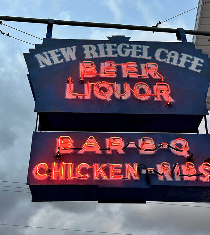 The iconic neon sign glows like a beacon for hungry travelers, promising BBQ salvation just steps away.