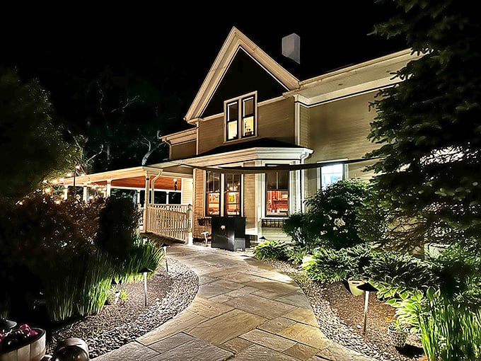 The farmhouse glows with warm light against the night sky, beckoning hungry travelers like a lighthouse for food lovers.