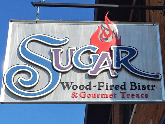 The distinctive signage announces Sugar Wood-Fired Bistro with pride, that little flame logo promising the wood-fired goodness waiting inside.