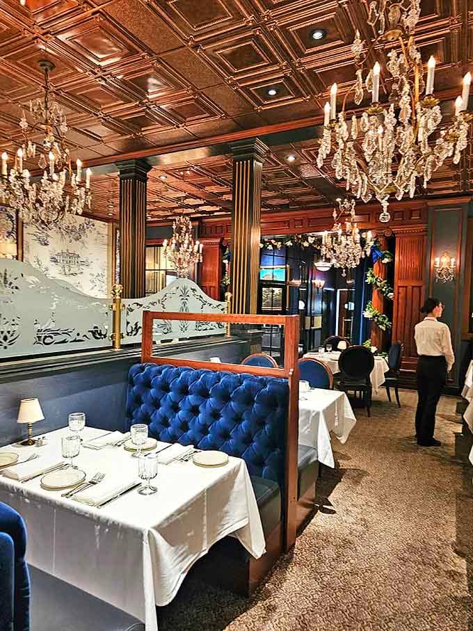 Crystal chandeliers cast a golden glow over the dining room, where each table setting awaits its moment in the culinary spotlight.