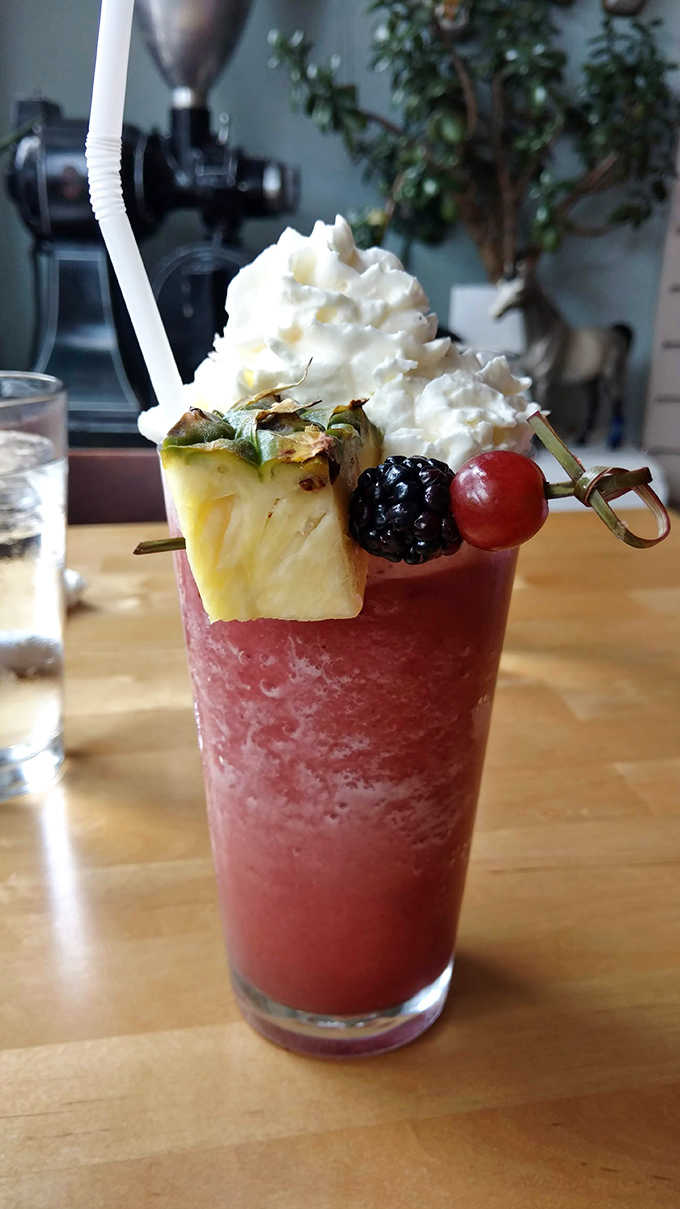 This fruit smoothie topped with whipped cream and fresh garnishes isn't just a drink &ndash; it's practically a portable dessert.