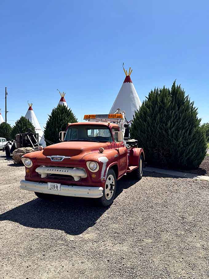 A vintage Chevrolet truck with perfect patina sits among the wigwams, looking like it's been waiting since 1955 for its next adventure.