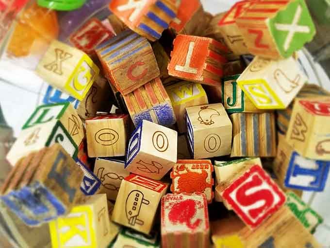 Wooden alphabet blocks tell stories of generations learning their letters, their faded colors evidence of tiny hands at play.