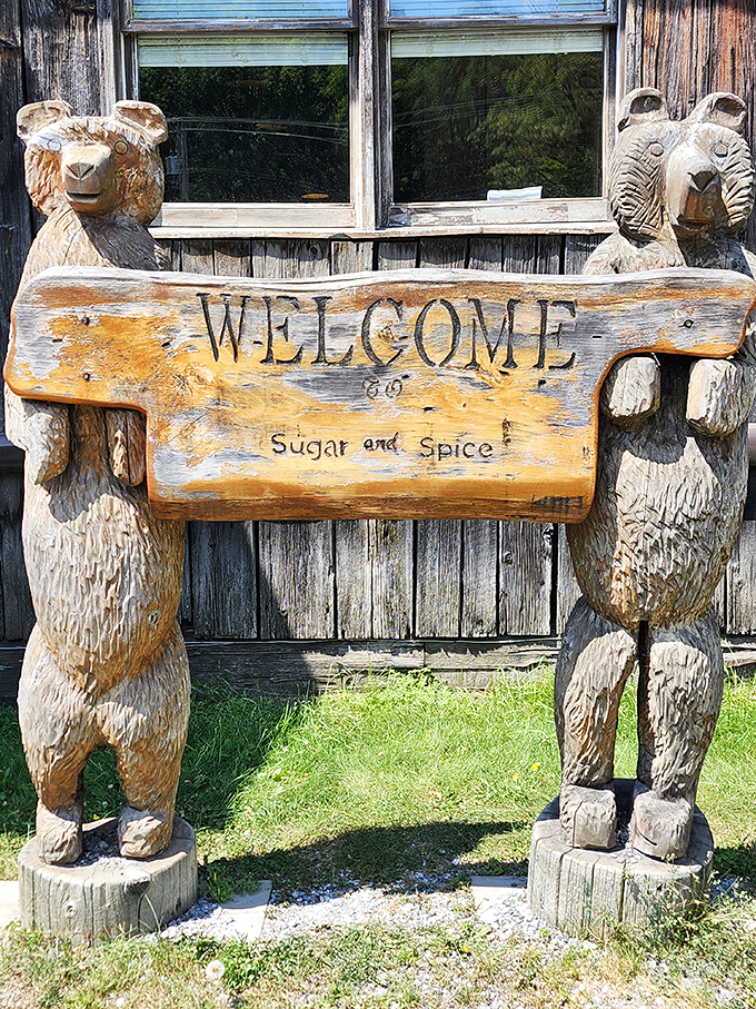 Wooden bears hold a welcome sign, their carved faces promising sweet and spicy delights within this maple wonderland.