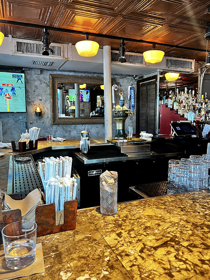 The counter experience offers front-row seats to culinary theater, where golden surfaces reflect light and every stool promises a different perspective on the bustling restaurant.