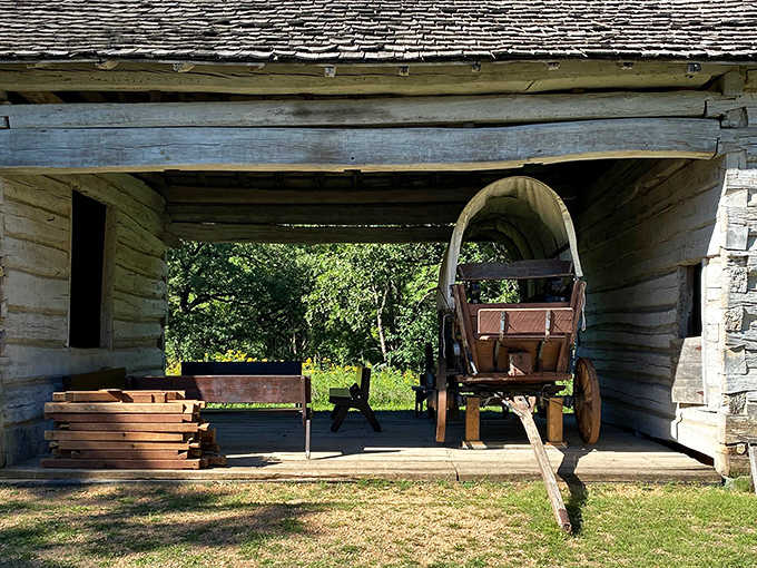 The covered wagon stands ready in its shelter, a humble vehicle that carried dreams, determination, and entire family histories westward.