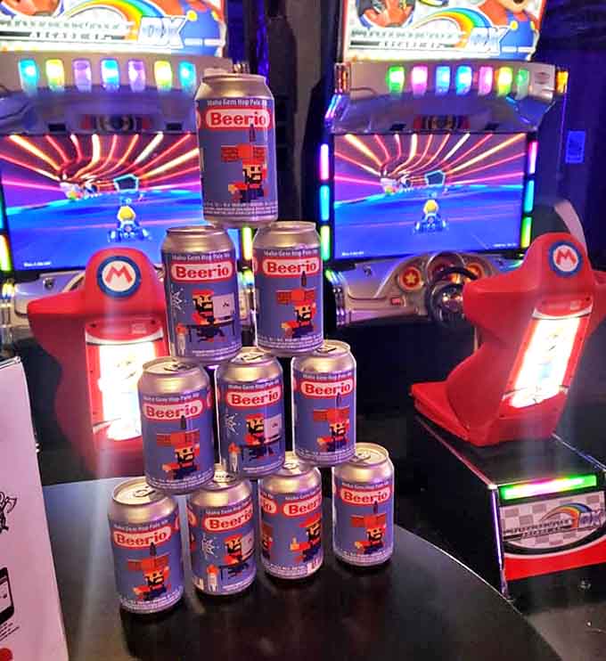 Mario Kart meets actual drinking in this meta gaming moment, where Beerio cans create a tower of temptation beside racing cabinets.