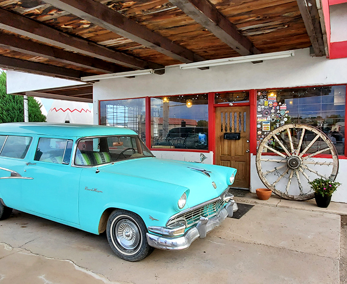 The turquoise classic car perfectly complements the motel's entrance, creating an irresistible photo opportunity for nostalgic travelers.