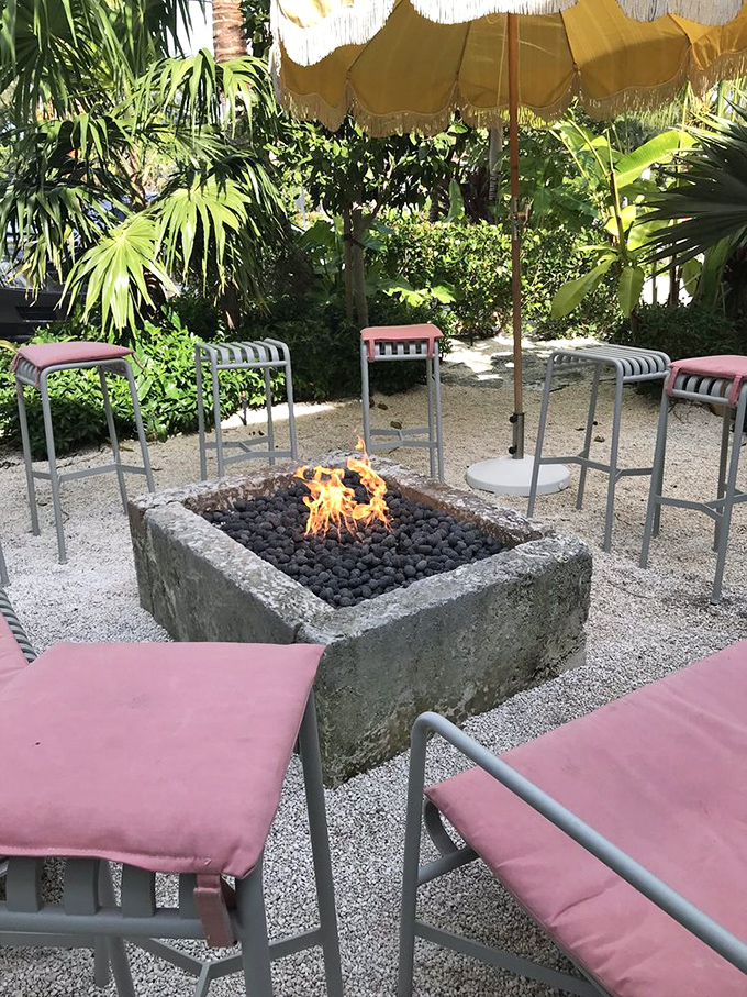 The stone fire pit creates a gathering spot for cooler evenings – where conversations flow as freely as the cocktails.