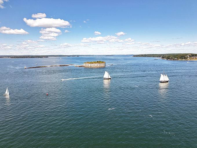 Sailboats glide past the silent sentinel, a peaceful scene far removed from the naval battles the fort was built to withstand.