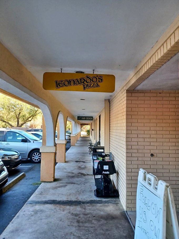The hallway sign points the way to pizza nirvana – a humble marker that locals recognize as the gateway to one of Gainesville's most treasured culinary institutions.