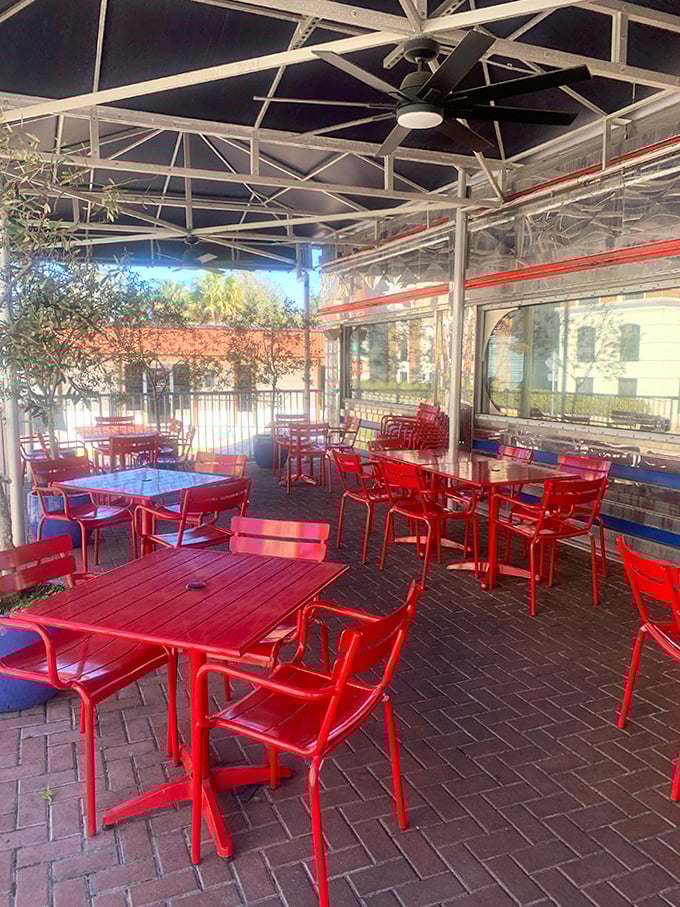 Bright red tables under a covered patio create the perfect spot for people-watching while demolishing a stack of pancakes.