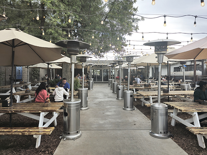 The outdoor seating area invites lingering under string lights, where Arizona evenings turn barbecue meals into memory-making occasions.