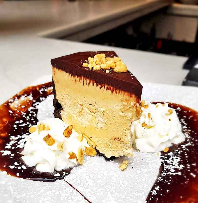 Dessert architecture at its finest – layers of peanut butter cheesecake that make you wonder if sharing was really such a good idea after all.