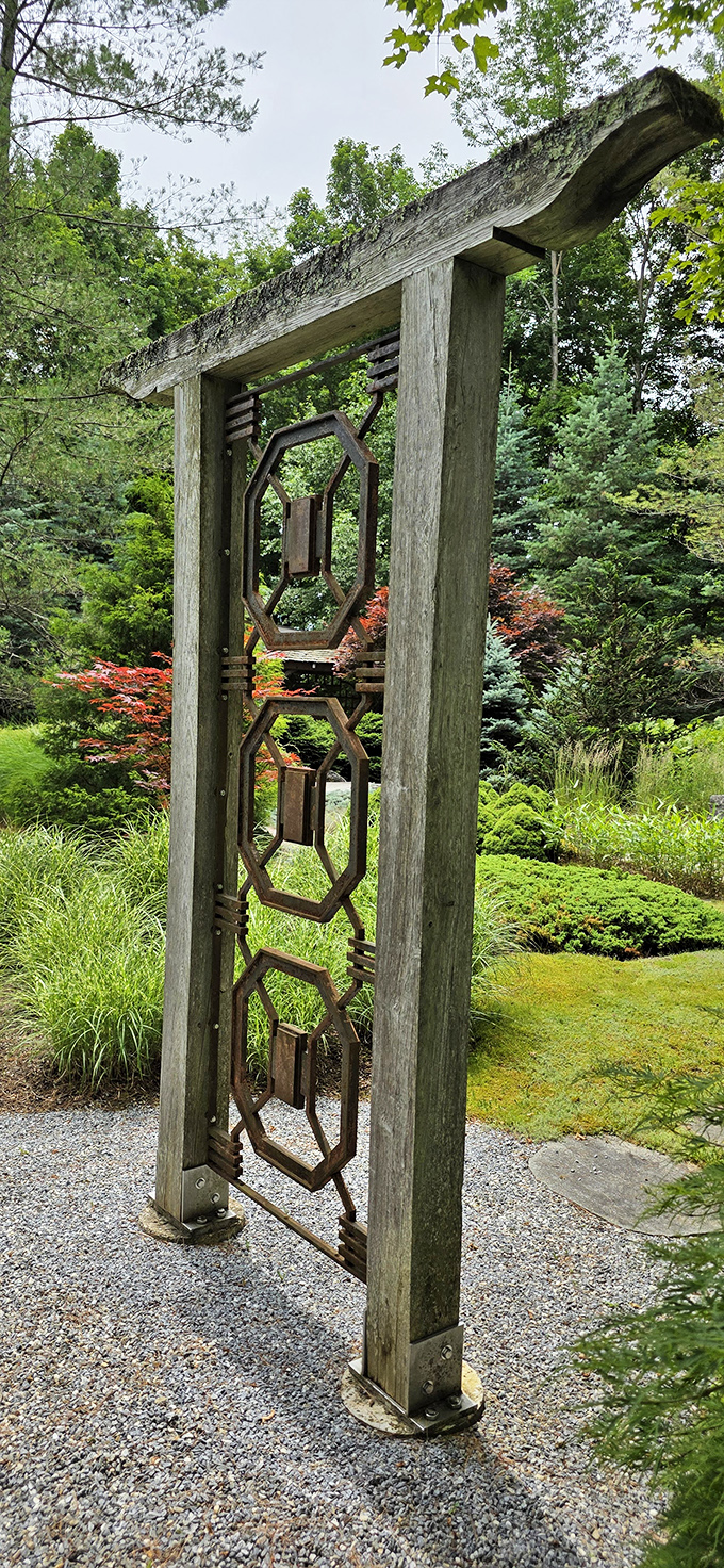 The sculptural archway frames the garden beyond, turning a simple walk into a ceremonial entrance worthy of royalty.