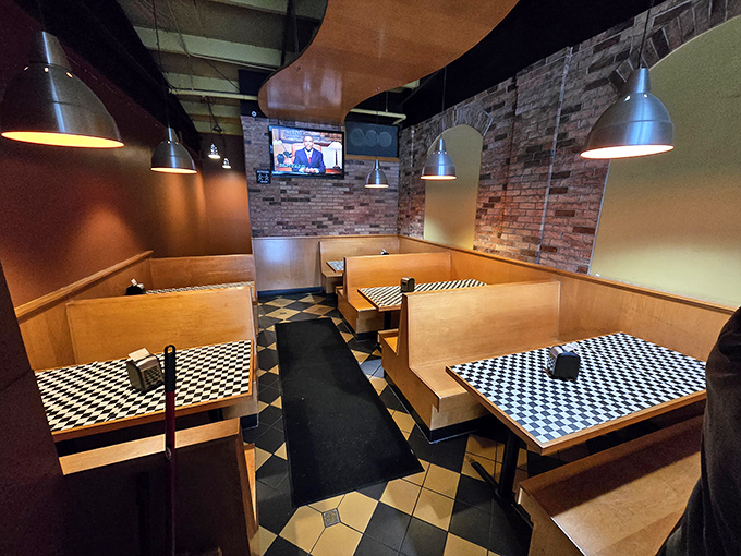 Cozy booths with checkered tables create intimate dining spaces where memories are made over plates of spectacular barbecue and sides.
