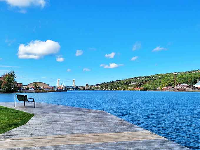A solitary bench on Houghton's waterfront boardwalk offers contemplative moments with uninterrupted views of Portage Lake's expansive beauty.