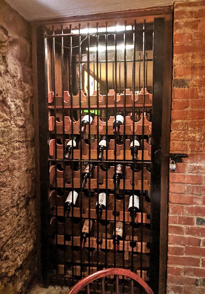 Behind these bars, wine bottles serve their time until released to accompany your perfectly grilled steak or seafood selection.